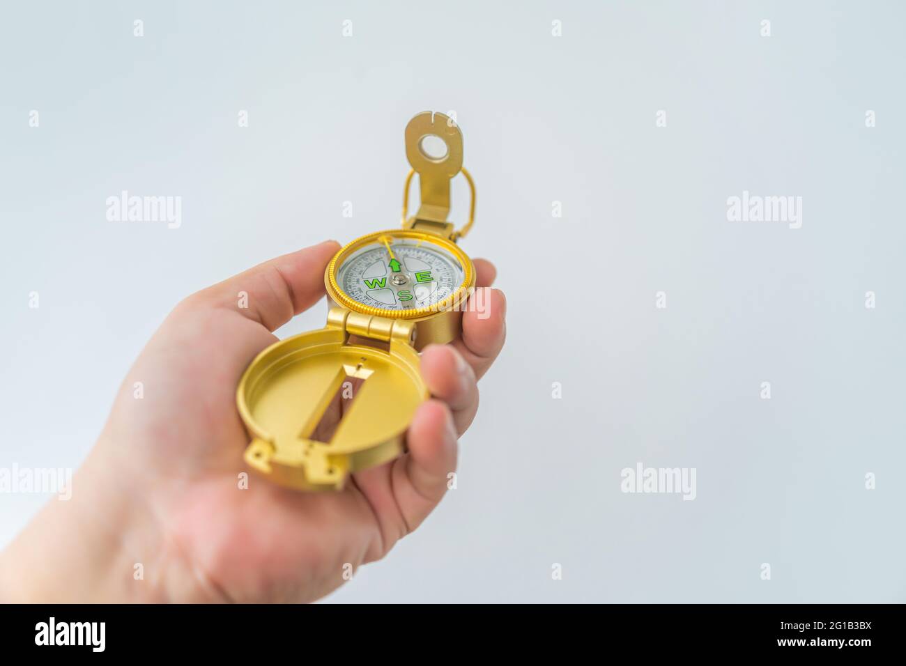 Hand holding golden compass isolated, shallow DOF, focus on dial ...
