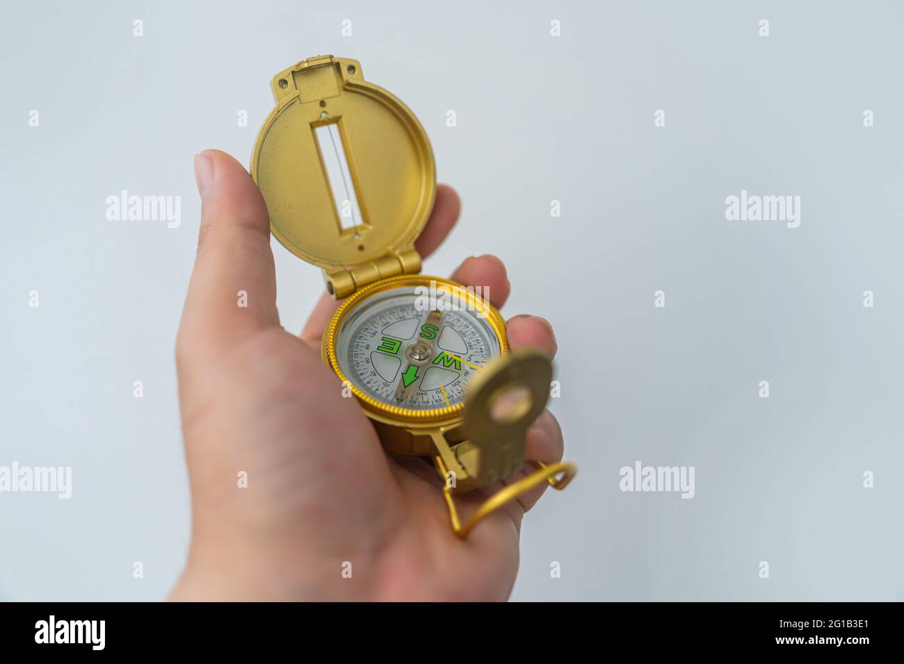 Hand holding golden compass isolated, shallow DOF, focus on dial ...