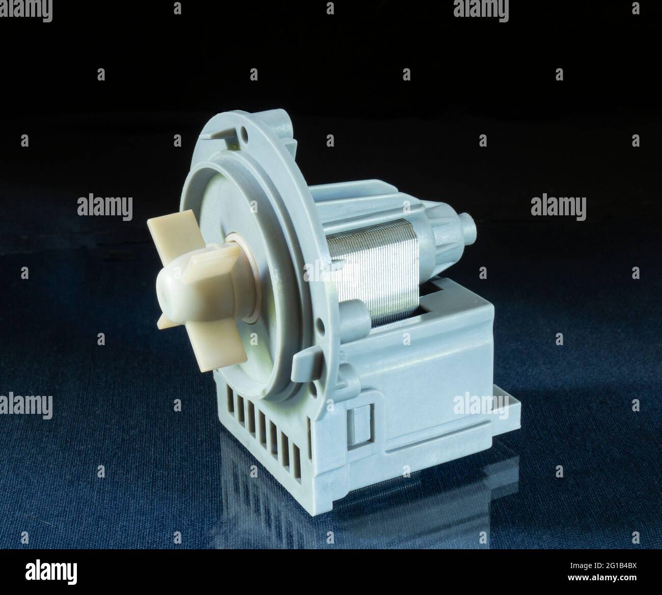 Washing machine pump on blue table with reflection. Equipment on a ...