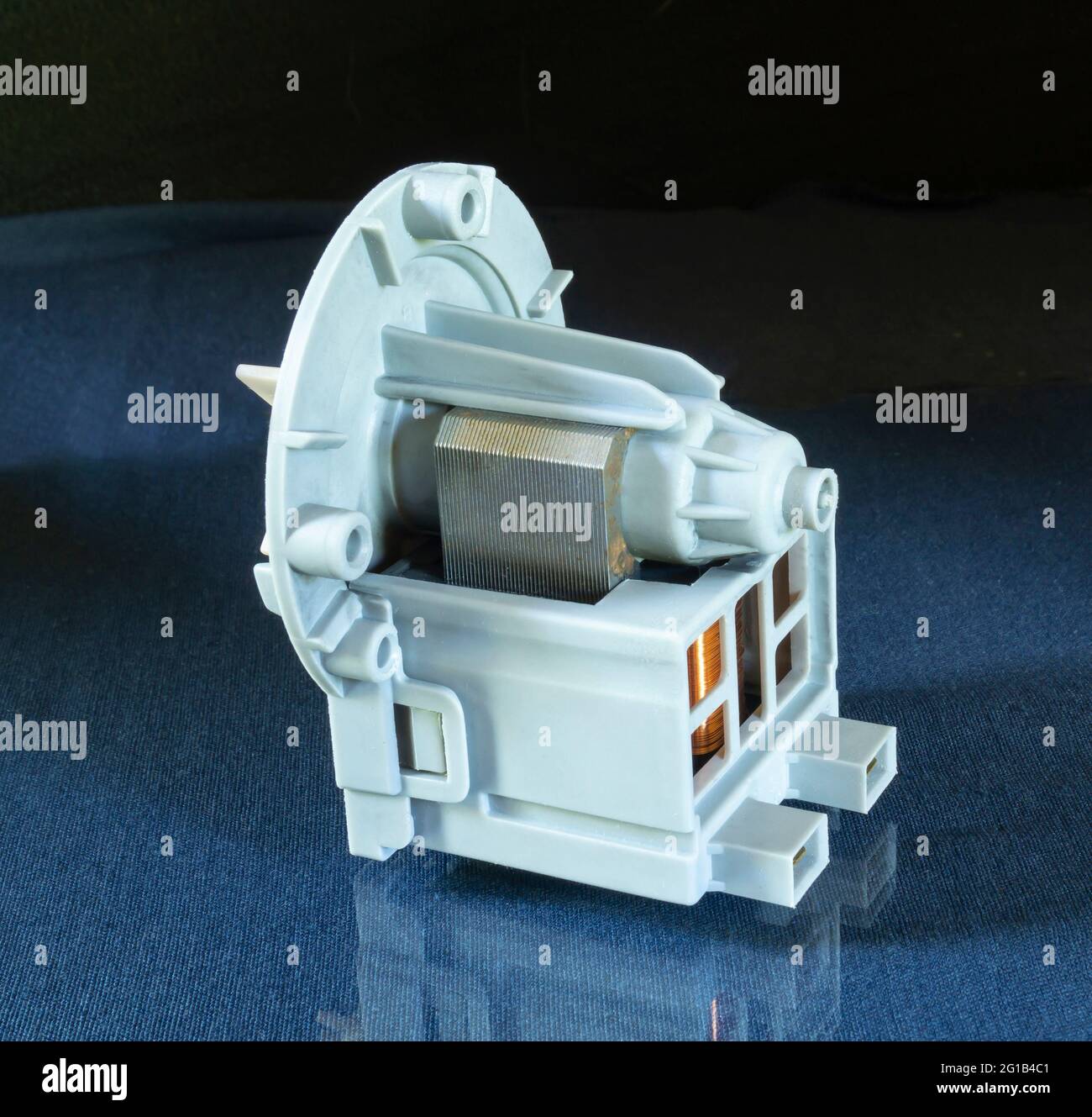 Washing machine pump on blue table with reflection. Equipment on a ...