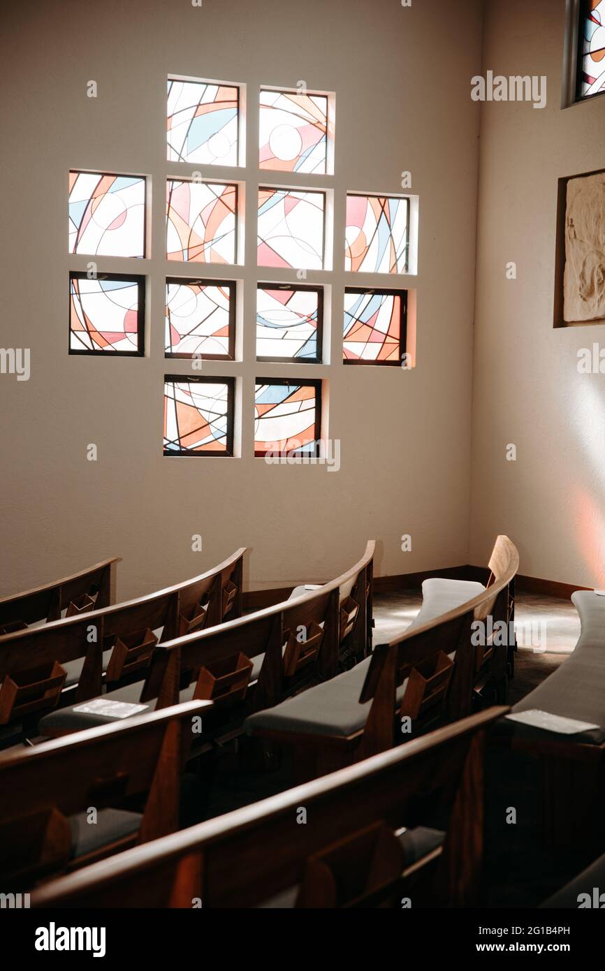Catholic church - starined glass window with rows of pews and pulpit ...