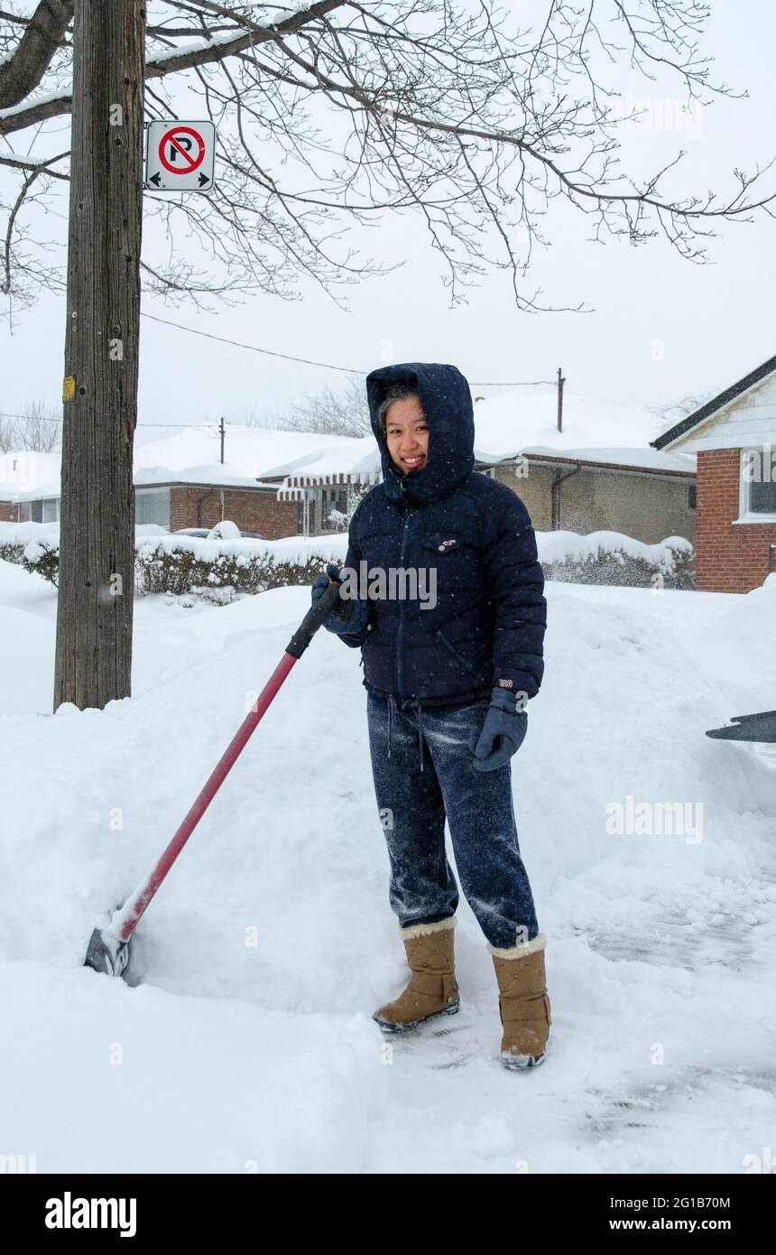 Family or people clearing the sidewalk of snow during the harsh Winter ...