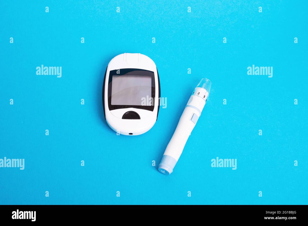 Blood glucose meter and lancet device an blue background close up Stock Photo - Alamy