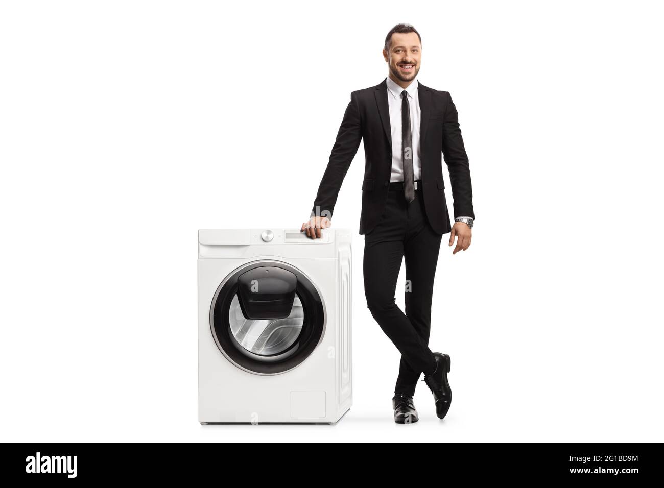 Full length portrait of a young an in a suit leaning on a washing ...