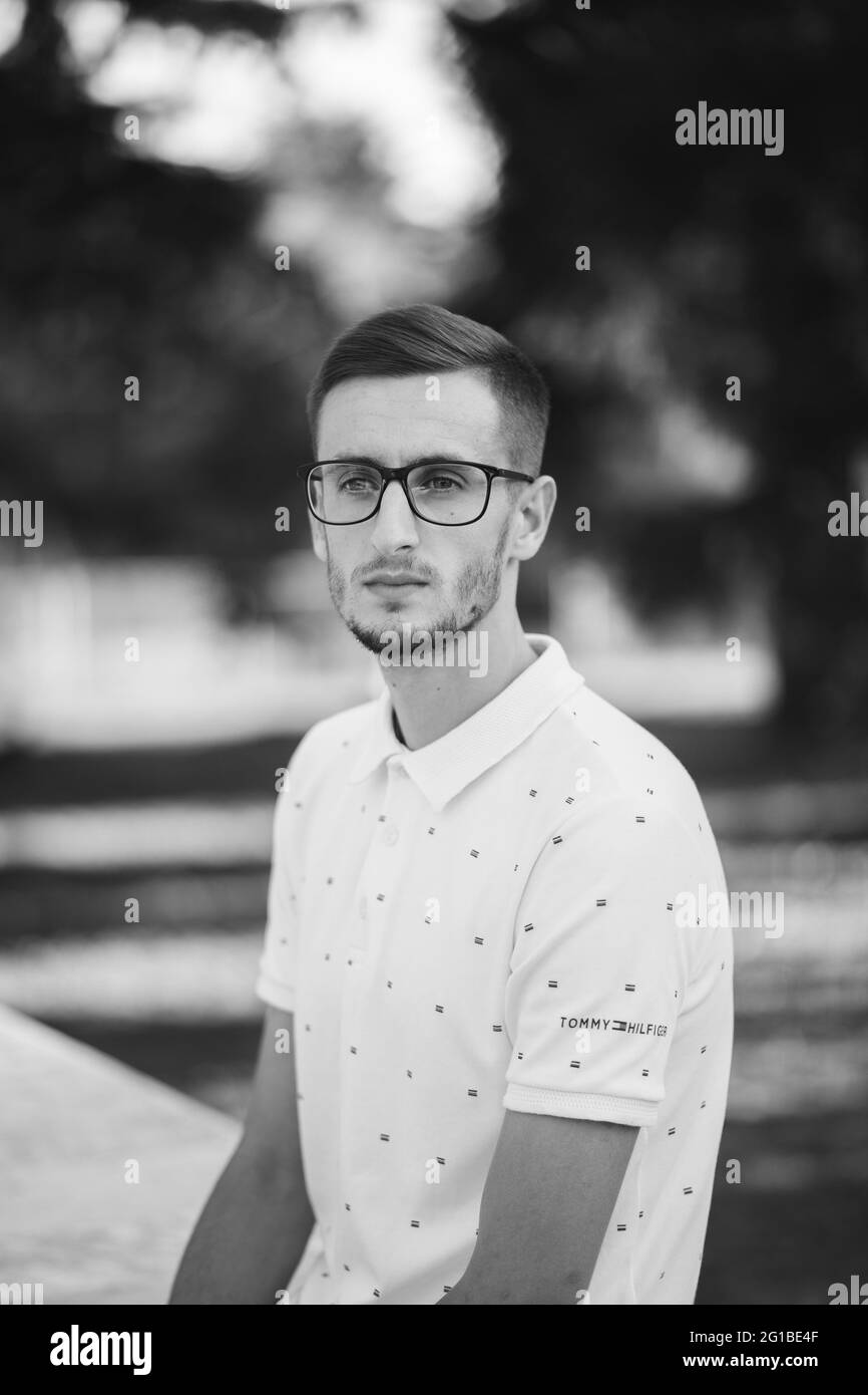 A grayscale shot of a handsome guy in glasses outdoor Stock Photo - Alamy