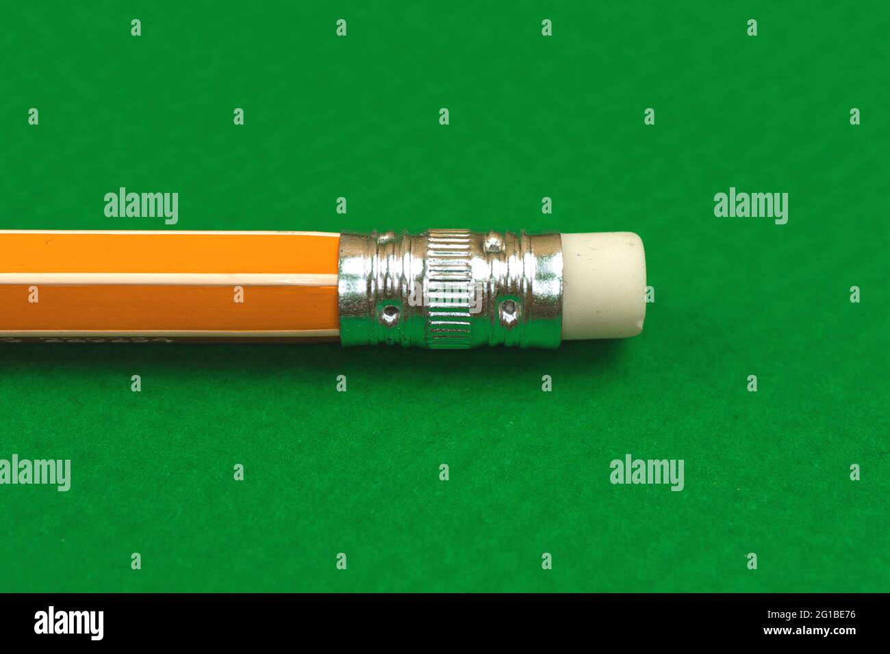 Close-up of school yellow pencil eraser, green table office desktop ...