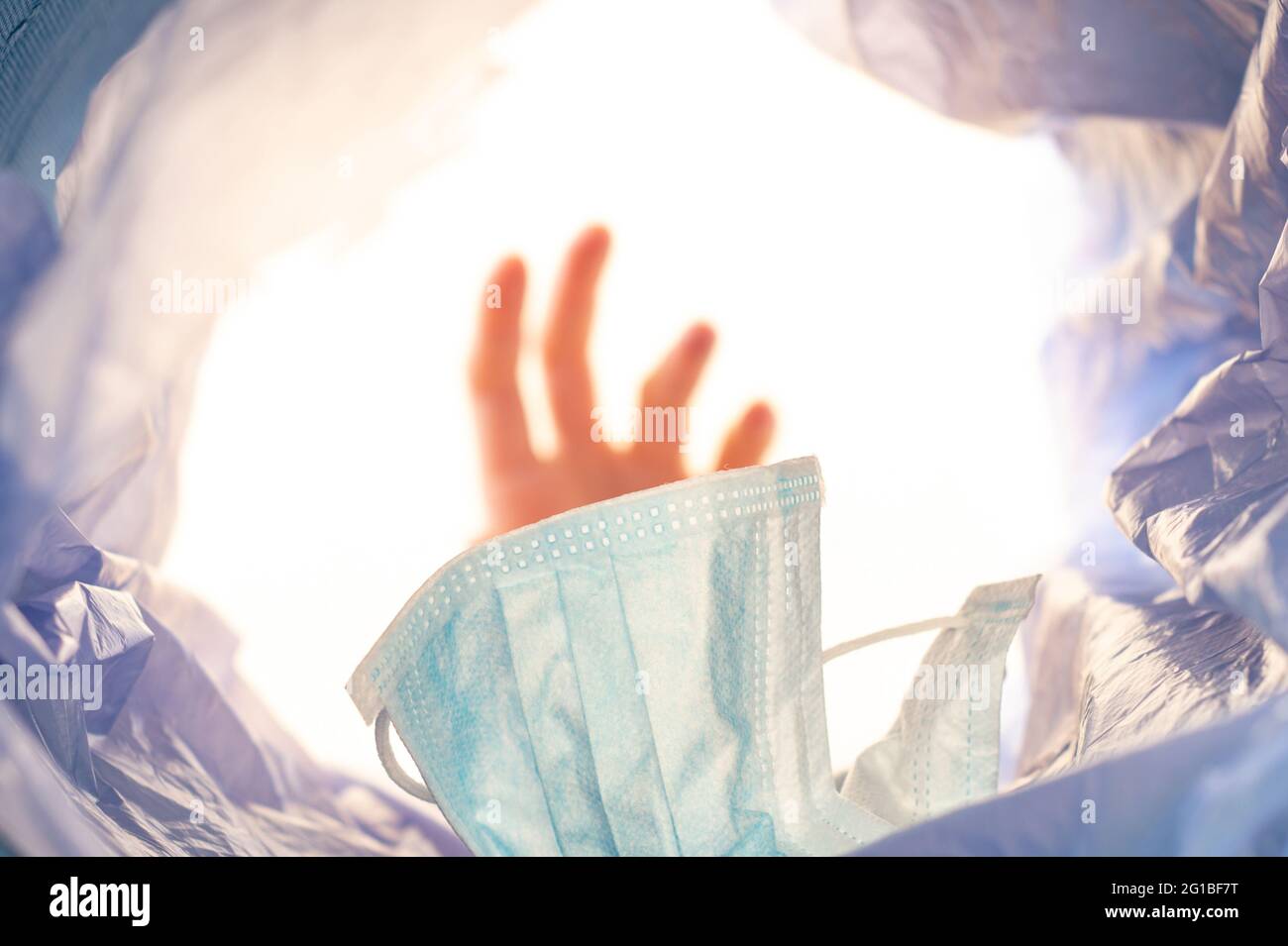 Throwing a face mask into the trash. With a view from the inside of the ...