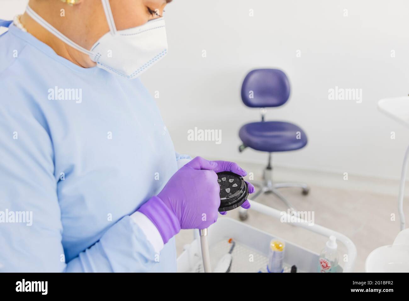 Adult female doctor in uniform and respiratory mask with small plate ...