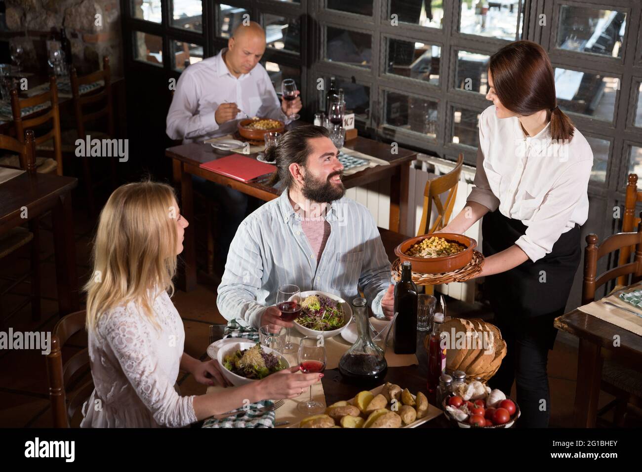Positive waitress bringing order hi-res stock photography and images ...