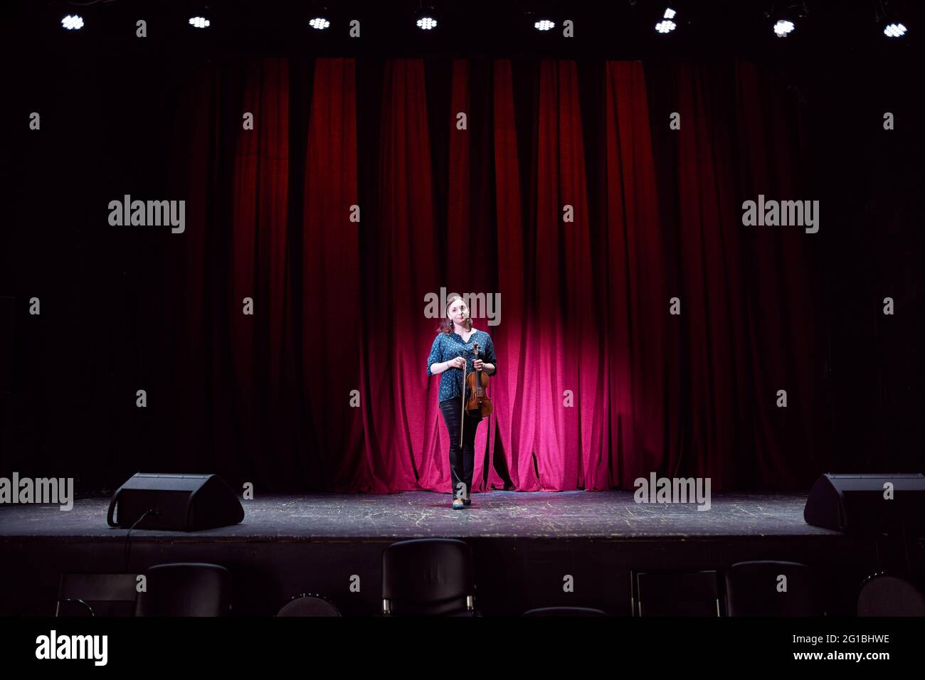 Full body professional female violinist performing live on stage in ...