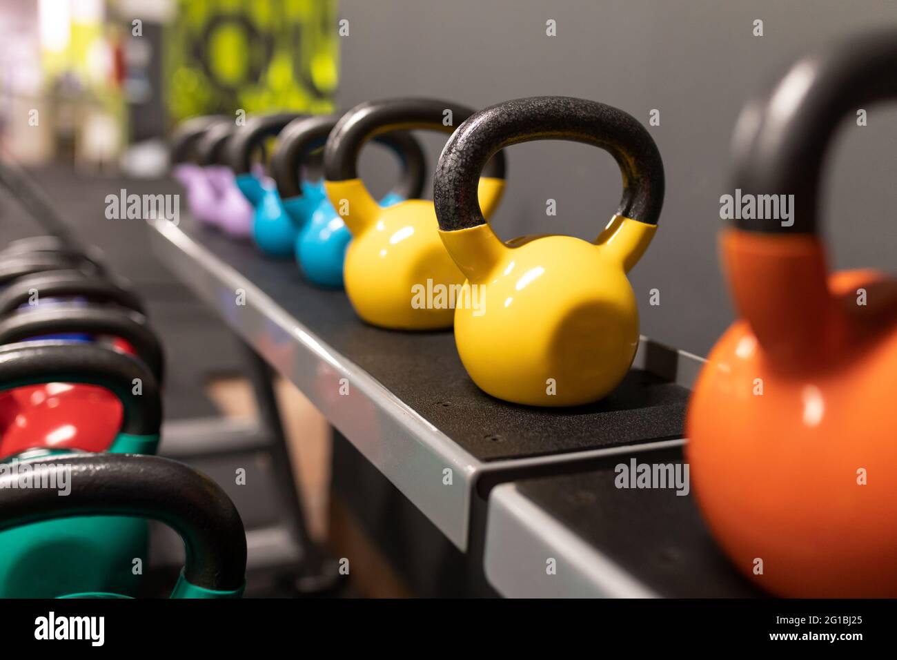 Set of colorful kettlebells of various weights placed in row in modern ...