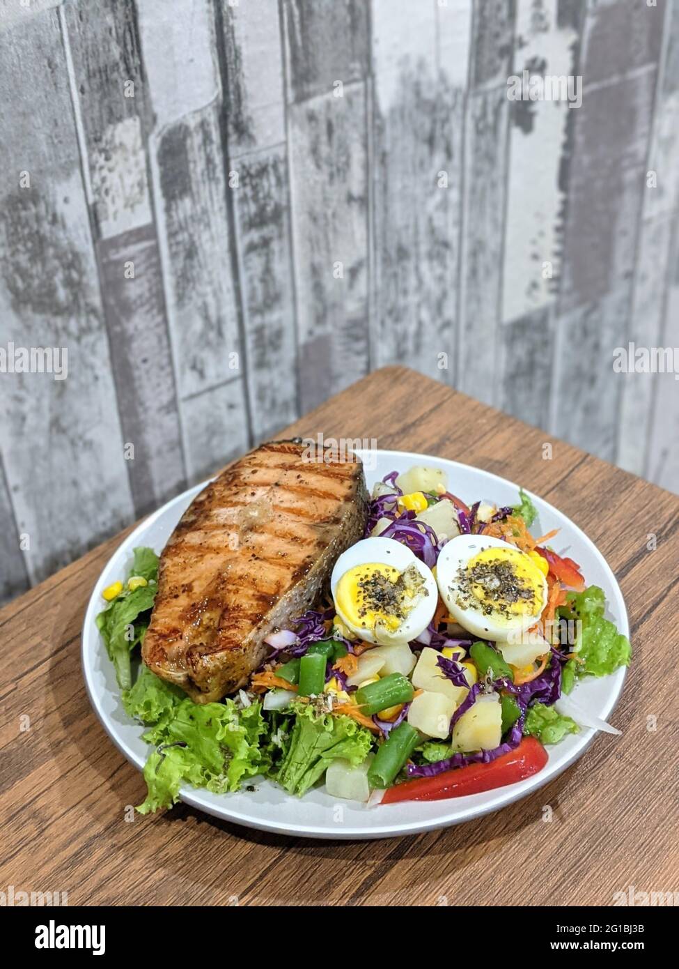 A vertical shot of a salmon steak with jumbo salad and egg Stock Photo ...