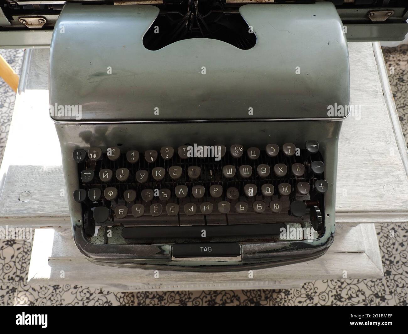 An old gray typewriter with white Cyrillic letters on black keys and ...