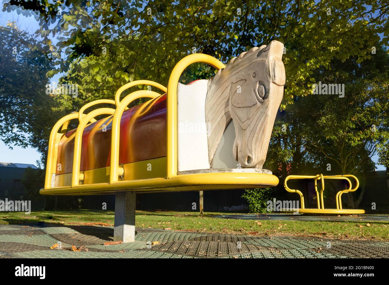 Yellow ride on playground horse with a carved out head Stock Photo - Alamy