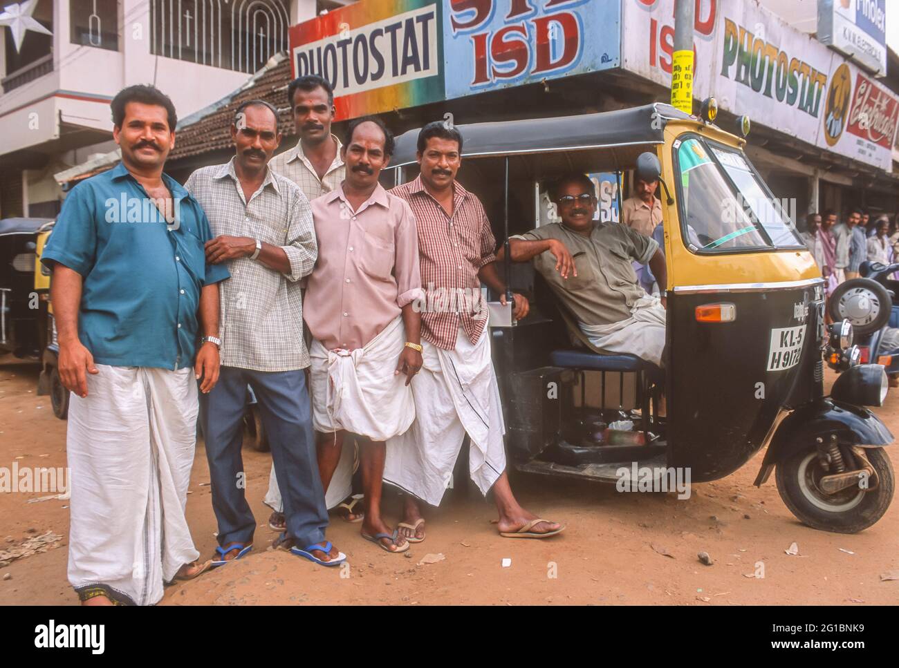 KERALA, INDIA - Group of men and auto rickshaw in village in western ...