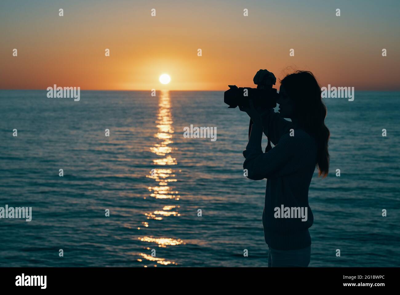 photographer with a camera at sunset near the sea Stock Photo - Alamy