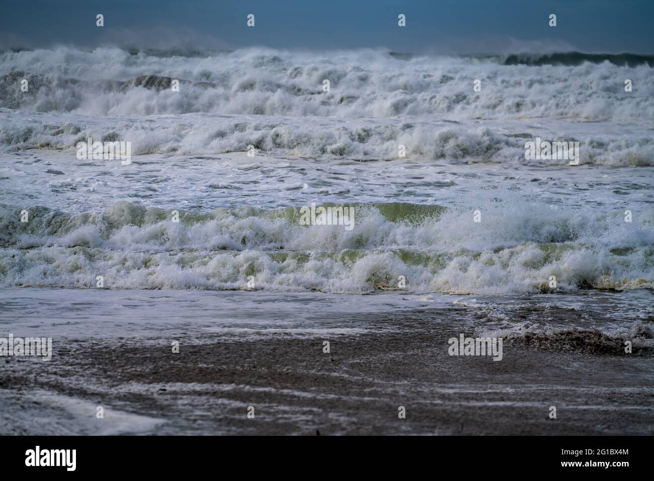 Dramatic storm waves crashing with spray flying on beach Stock Photo ...