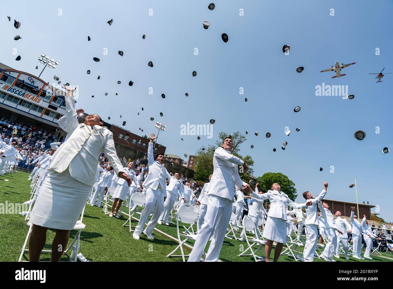 Cadets toss their caps during a Coast Guard flyover at the conclusion ...