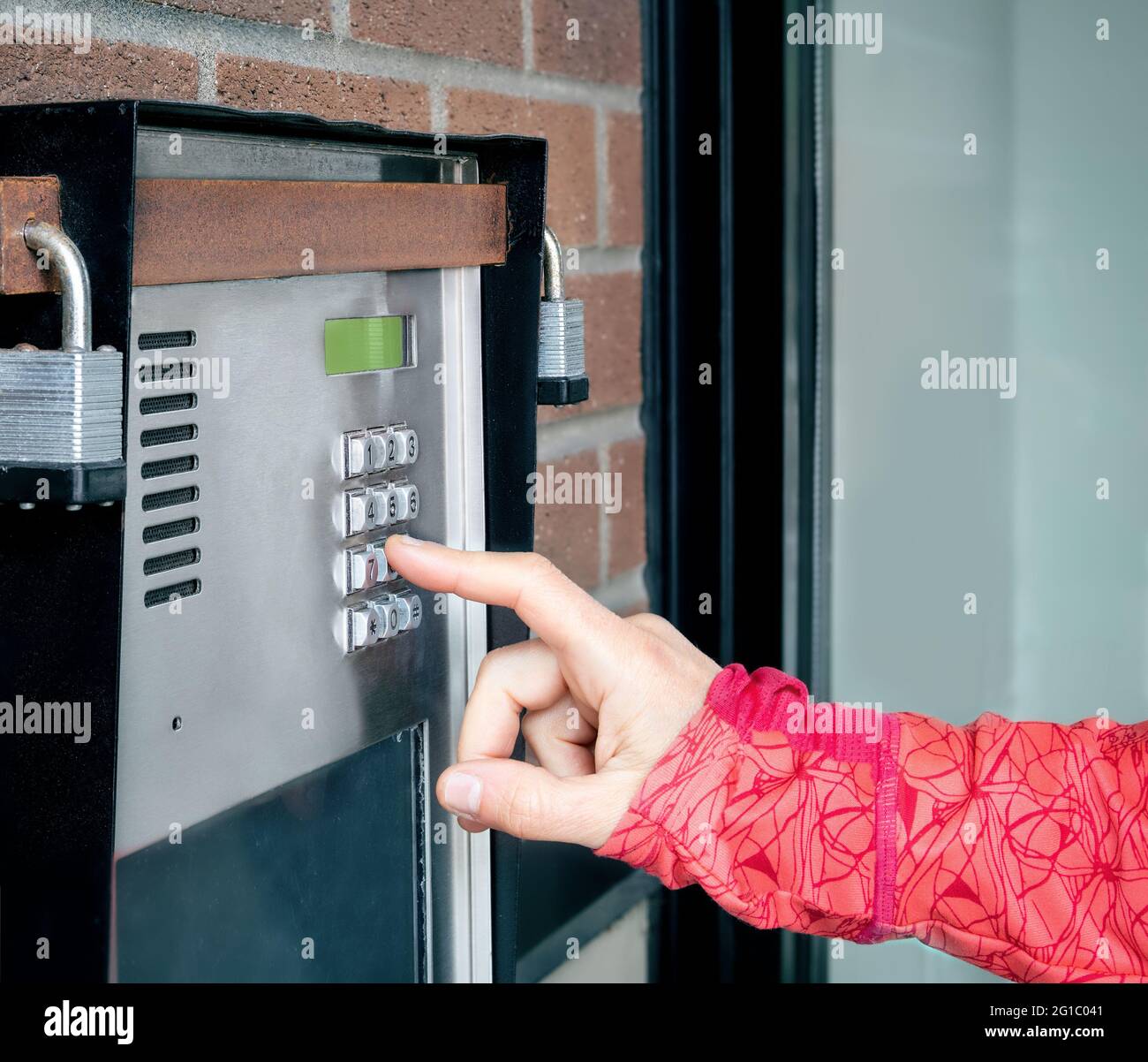 Person using building enterphone or intercom. Fingers are on number pad ...