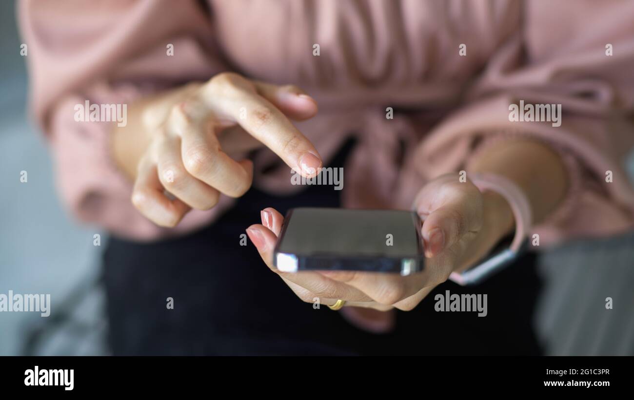 Close up view of female hand using smartphone, finger texting on phone ...