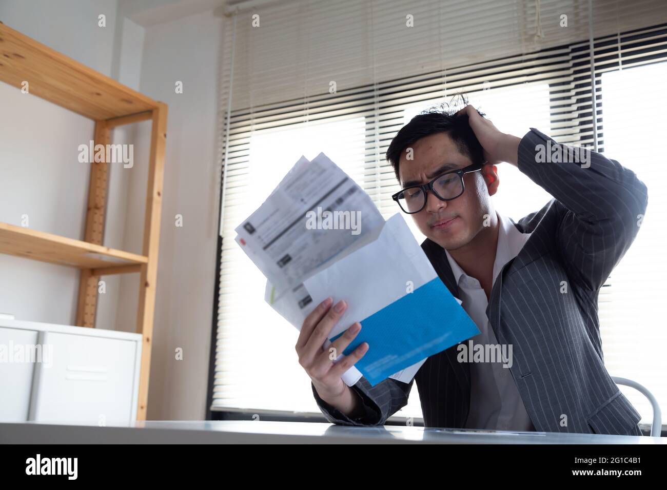 Sad confused and stressed of young Asian man holding bills letter of ...