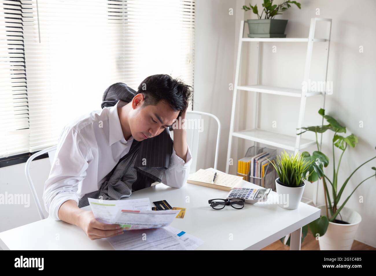 Sad confused and stressed of young Asian man holding bills letter of ...