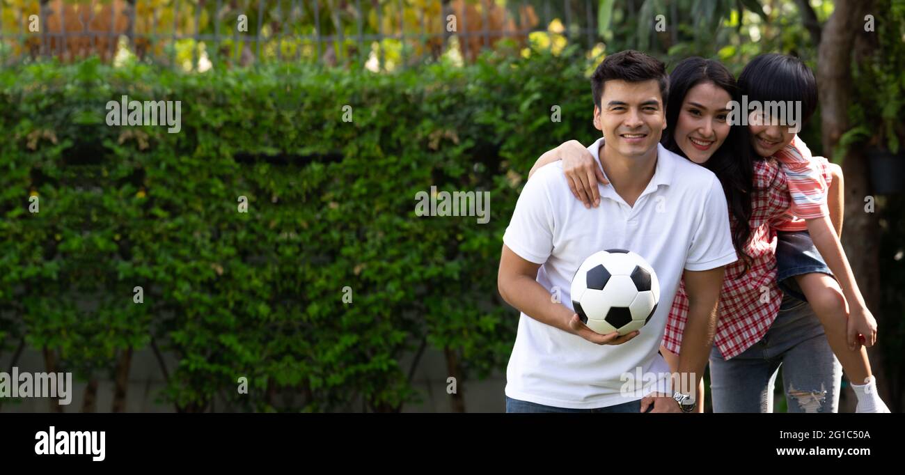 Family playing football or soccer in green garden together their ...