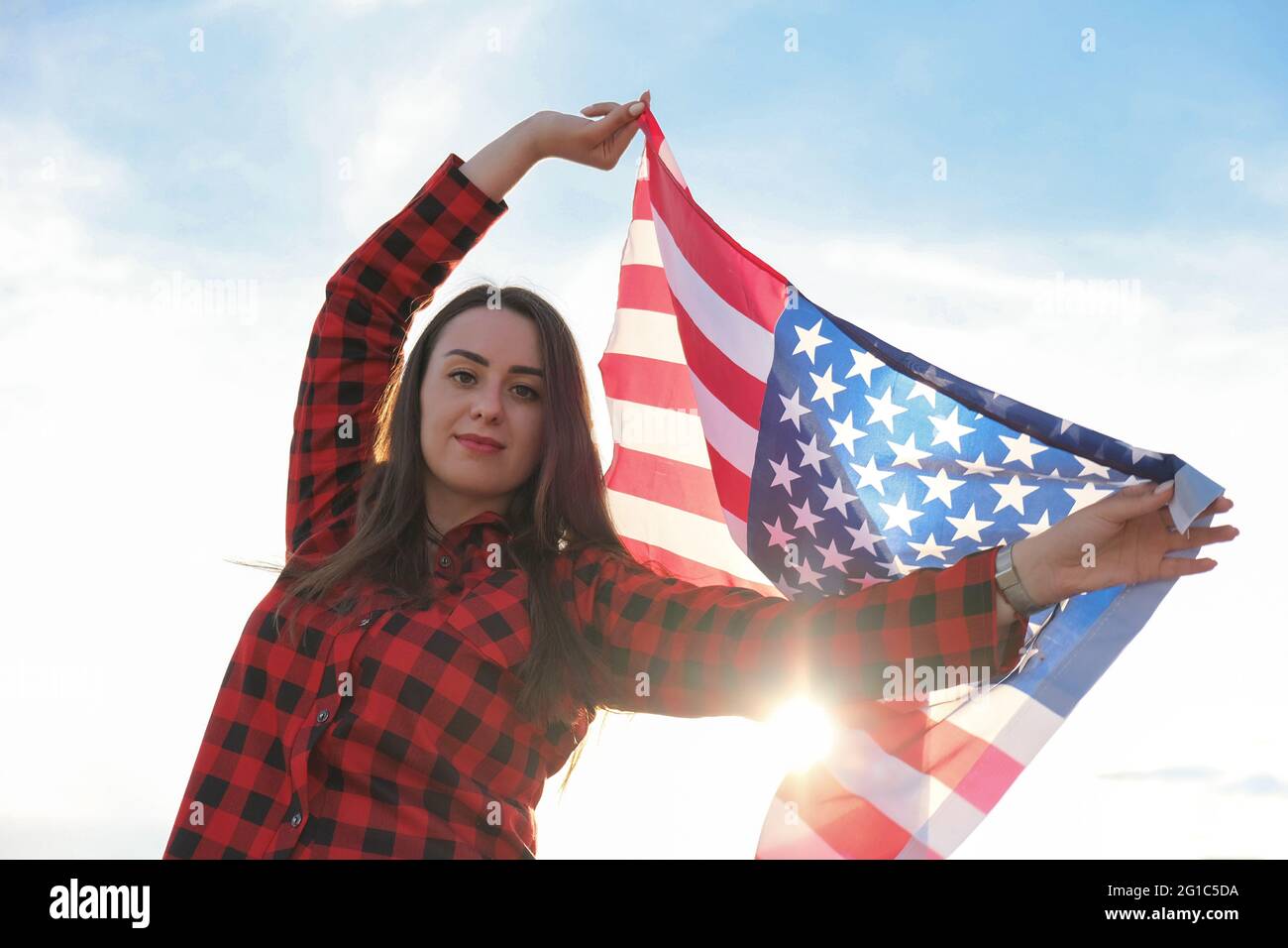 Young millennial brunette woman holding The National Flag of USA ...