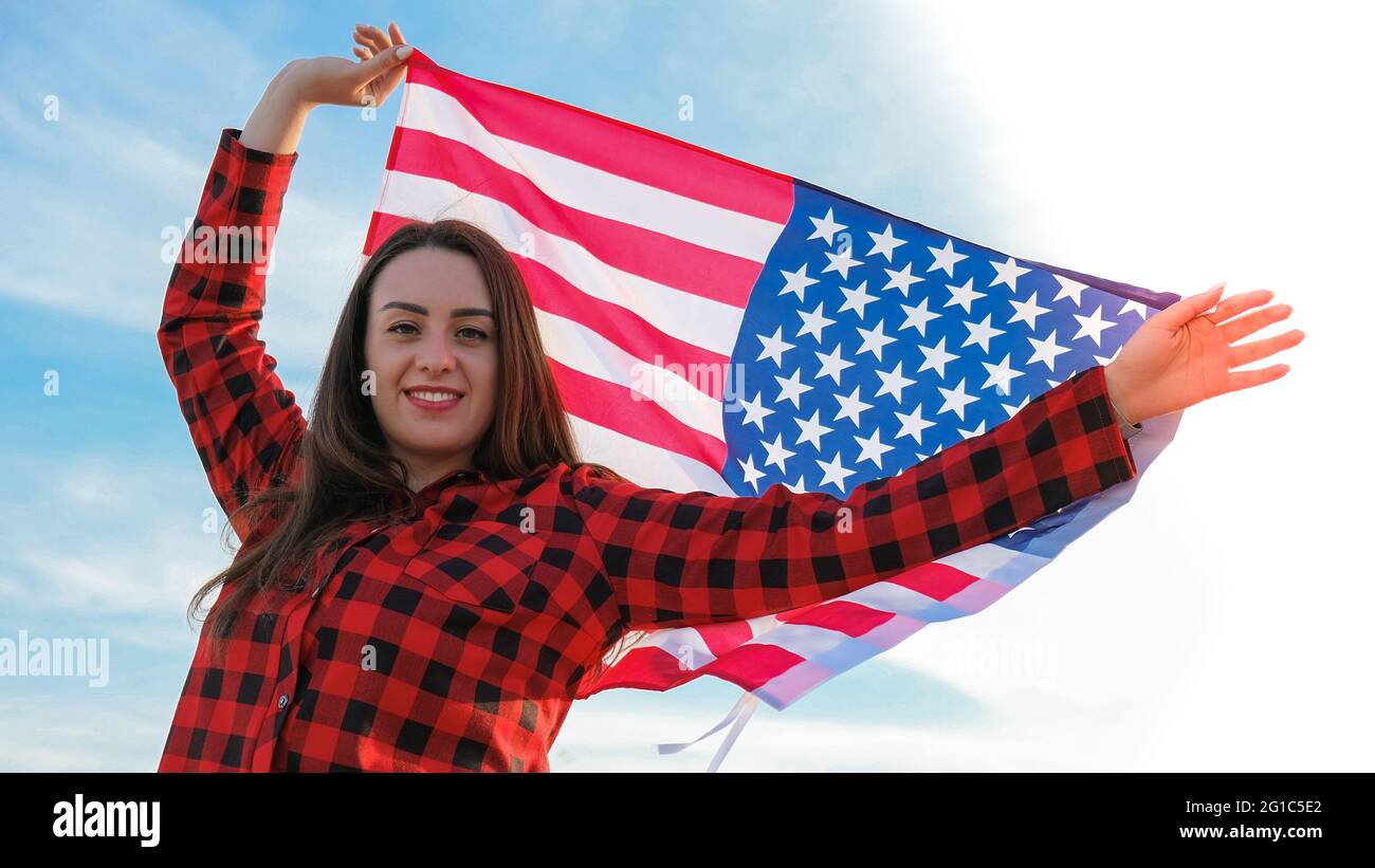 Young millennial brunette woman holding The National Flag of USA ...