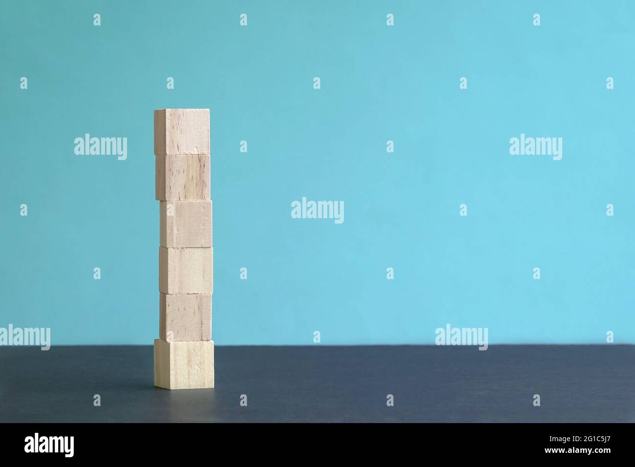 6 letter blank and wood block stacked up, blue background. Copy space ...