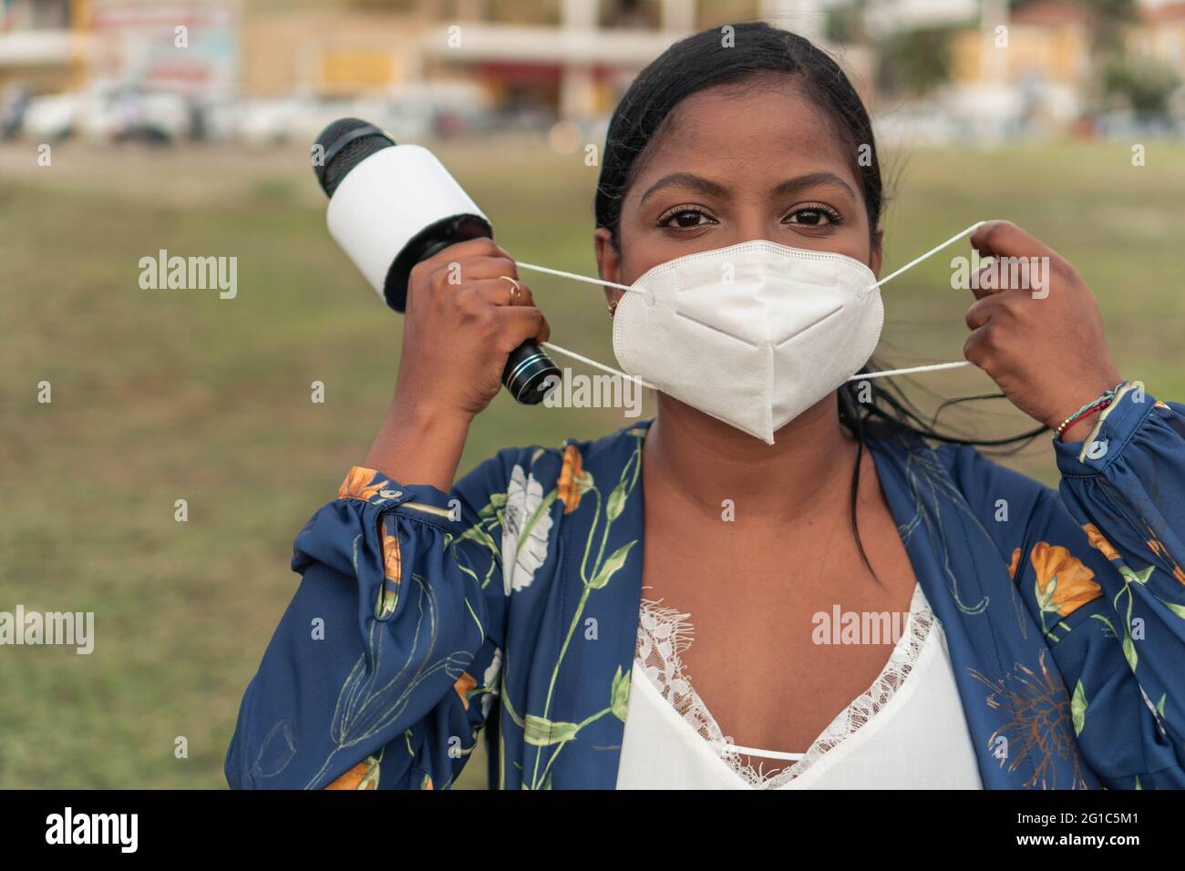 Female journalist donning face mask while on the street in the city ...
