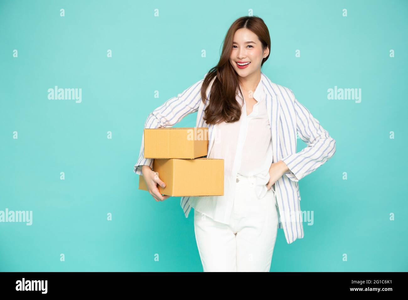 Happy Asian woman smiling and holding package parcel box isolated on ...