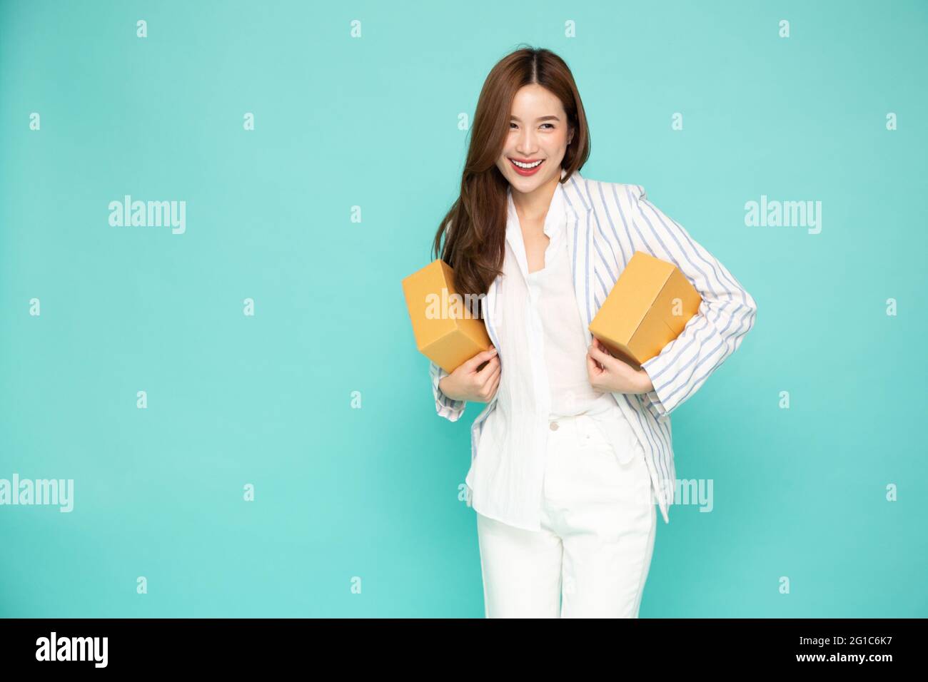 Happy Asian woman smiling and holding package parcel box isolated on ...