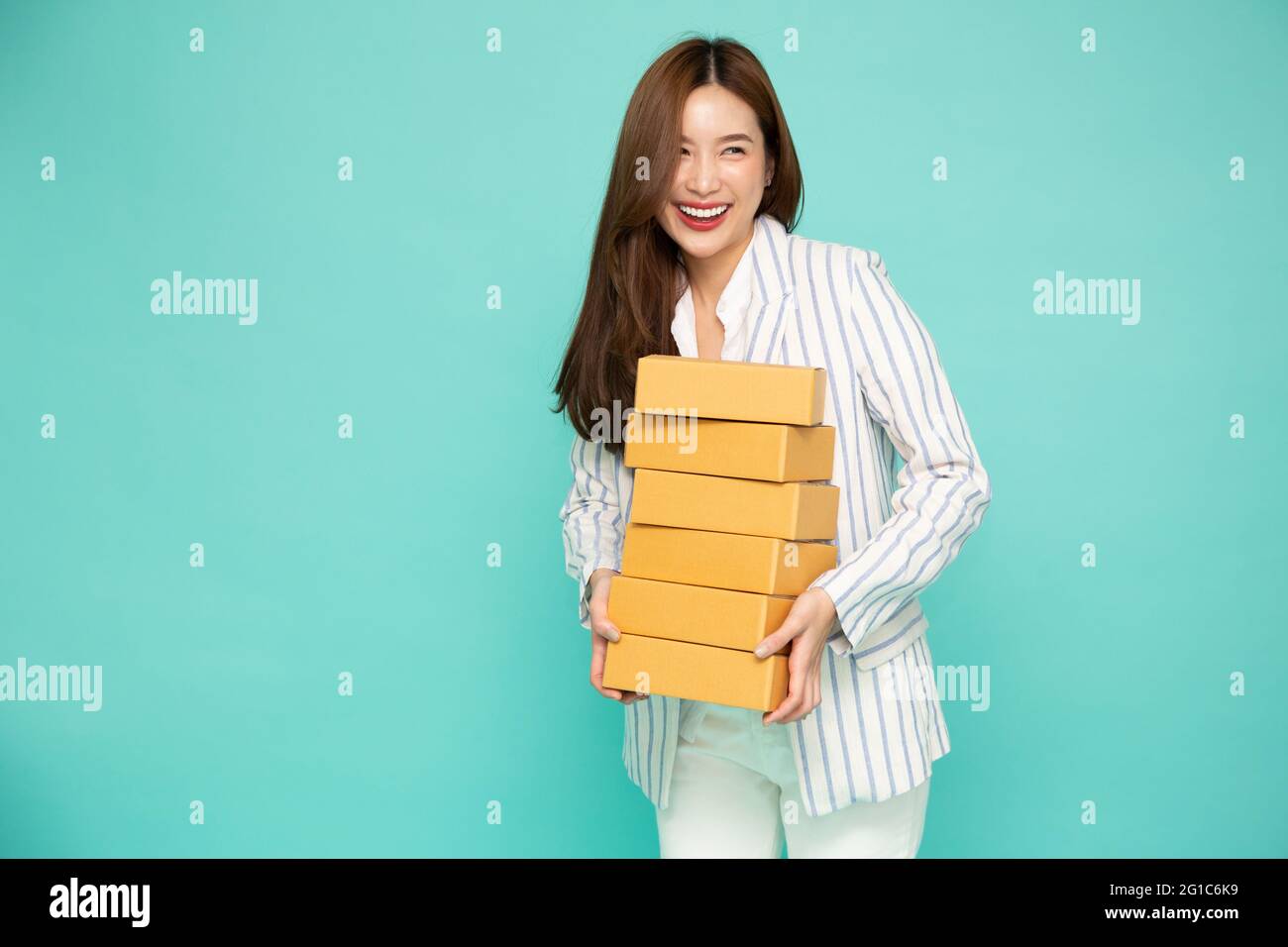 Happy Asian woman smiling and holding package parcel box isolated on ...