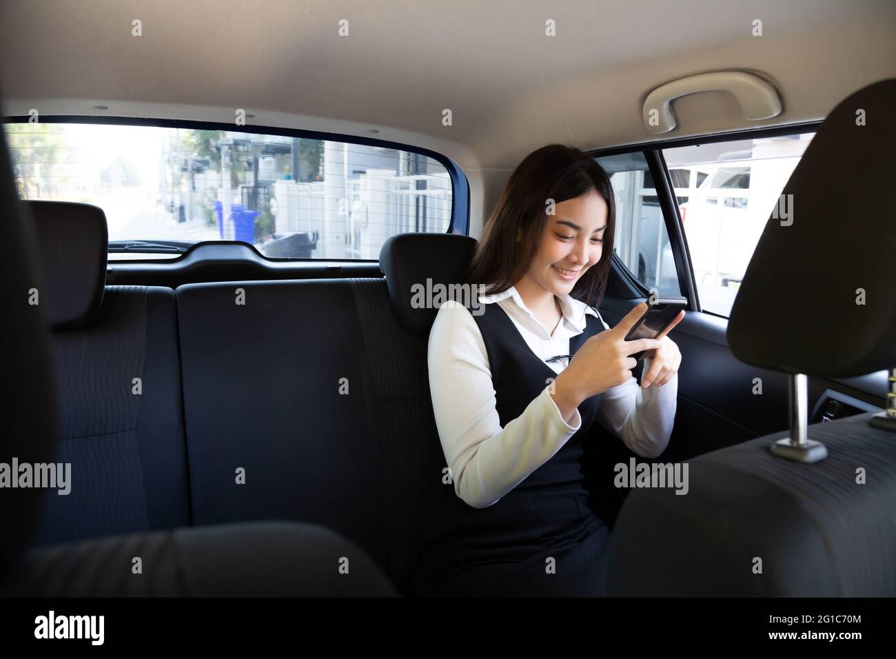 Asian teenager woman using a smartphone in back seat of car, Passengers ...