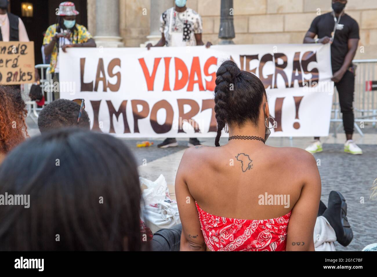 A protester with a tattoo of the African continent is seen in front of ...