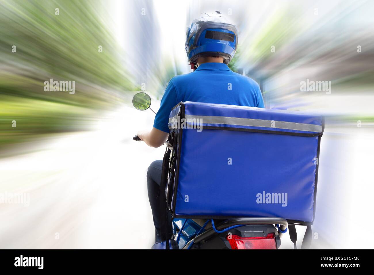 Delivery man wearing blue uniform riding motorcycle and delivery box ...