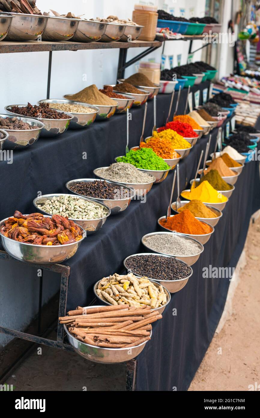 Rows of colourful Indian spices laid out on shelves in dishes, Patnem ...