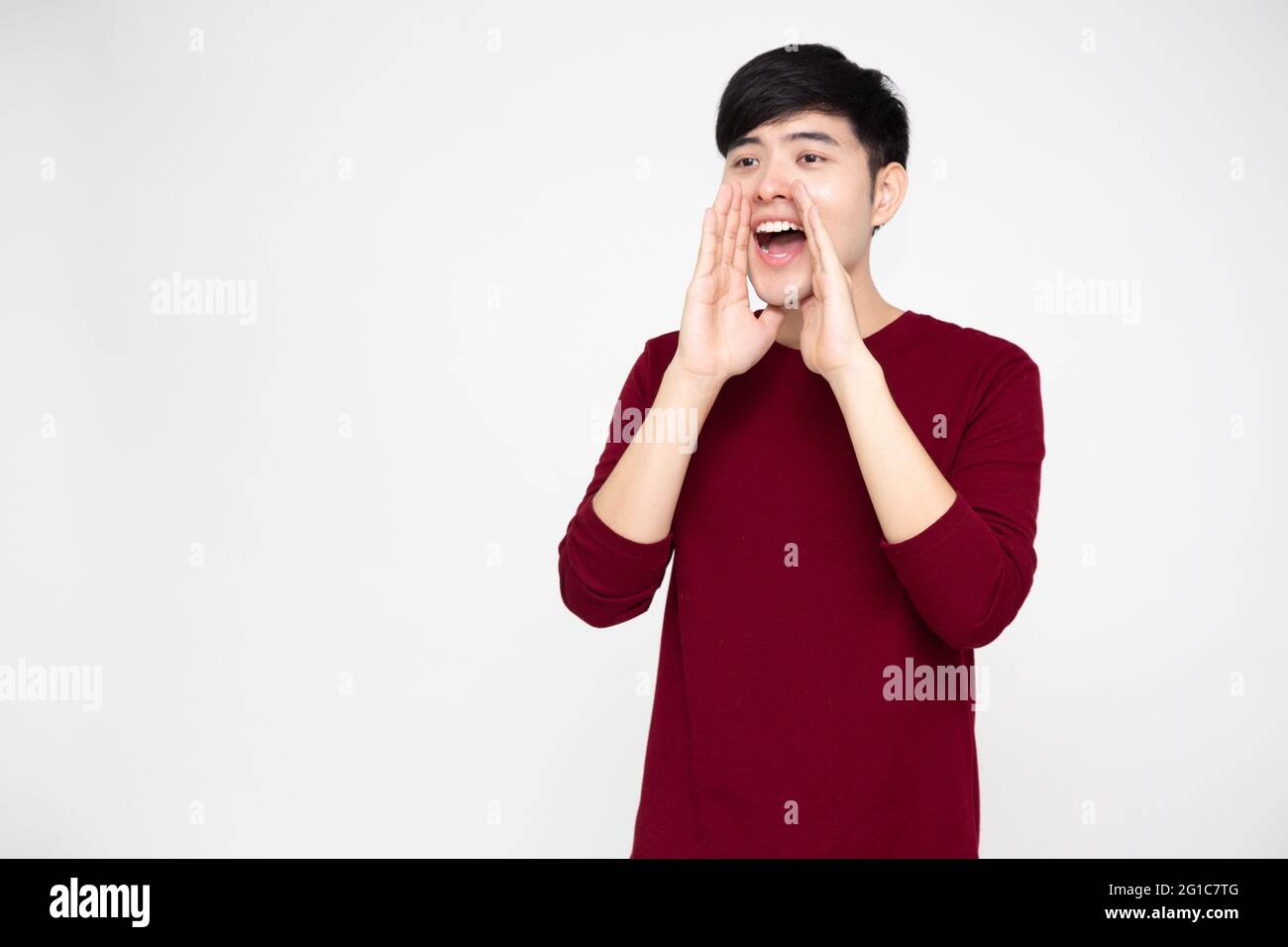 Portrait of excited screaming young asian man isolated over white ...