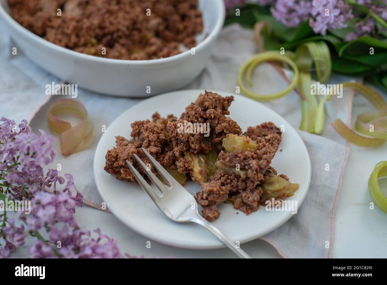 sweet home made chocolate rhubarb crumble with lilach flowers Stock ...