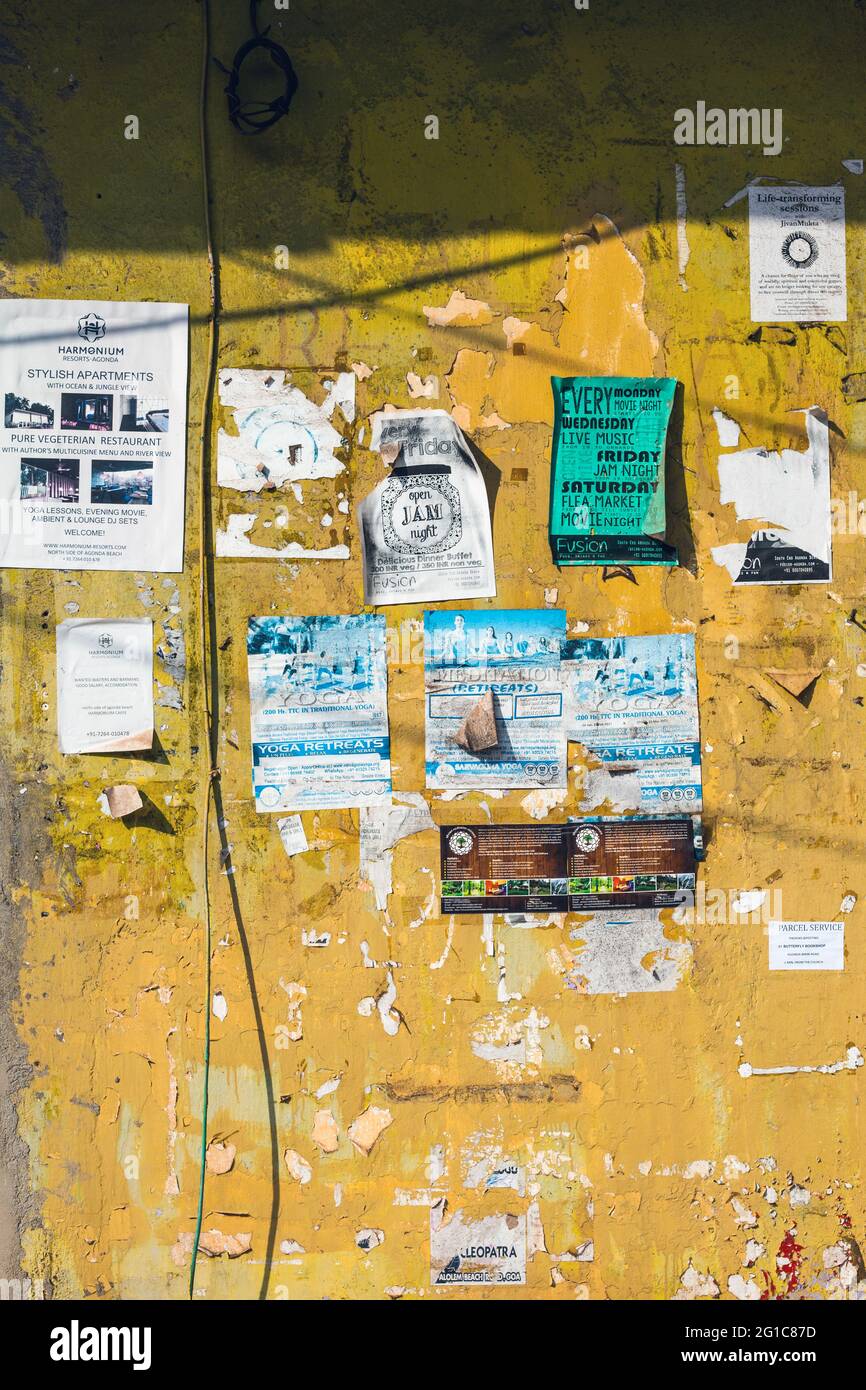 Public notices on a yellow wall advertising businesses and services ...