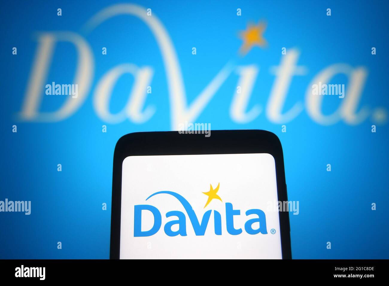 In this photo illustration, a DaVita logo is seen on a smartphone and a ...