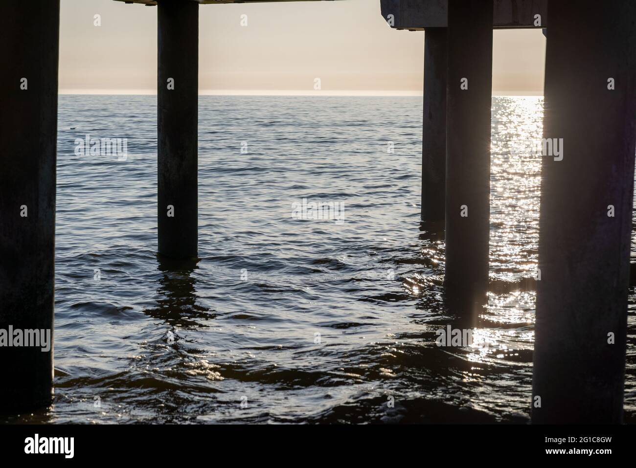 Columnar bridge piers at sunset.View under the bridge into sea with ...