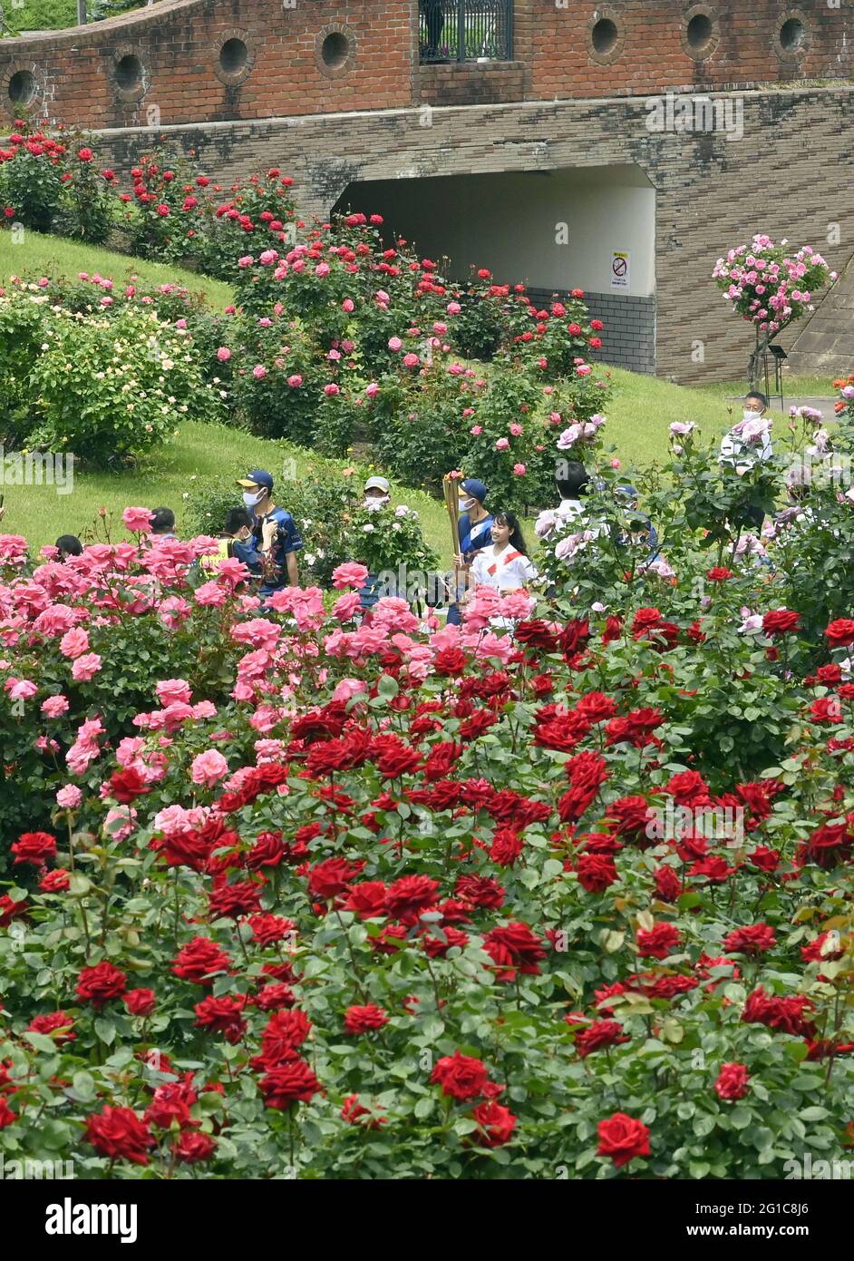 A Tokyo Olympic torch relay participant runs at Higashizawa Rose Park ...