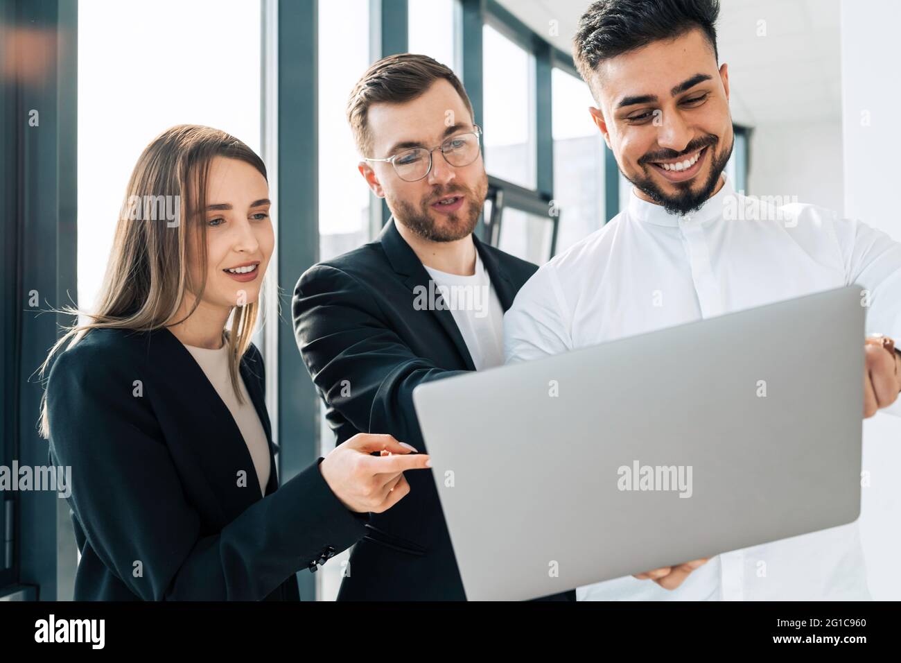 Three business people using laptop in office Stock Photo - Alamy