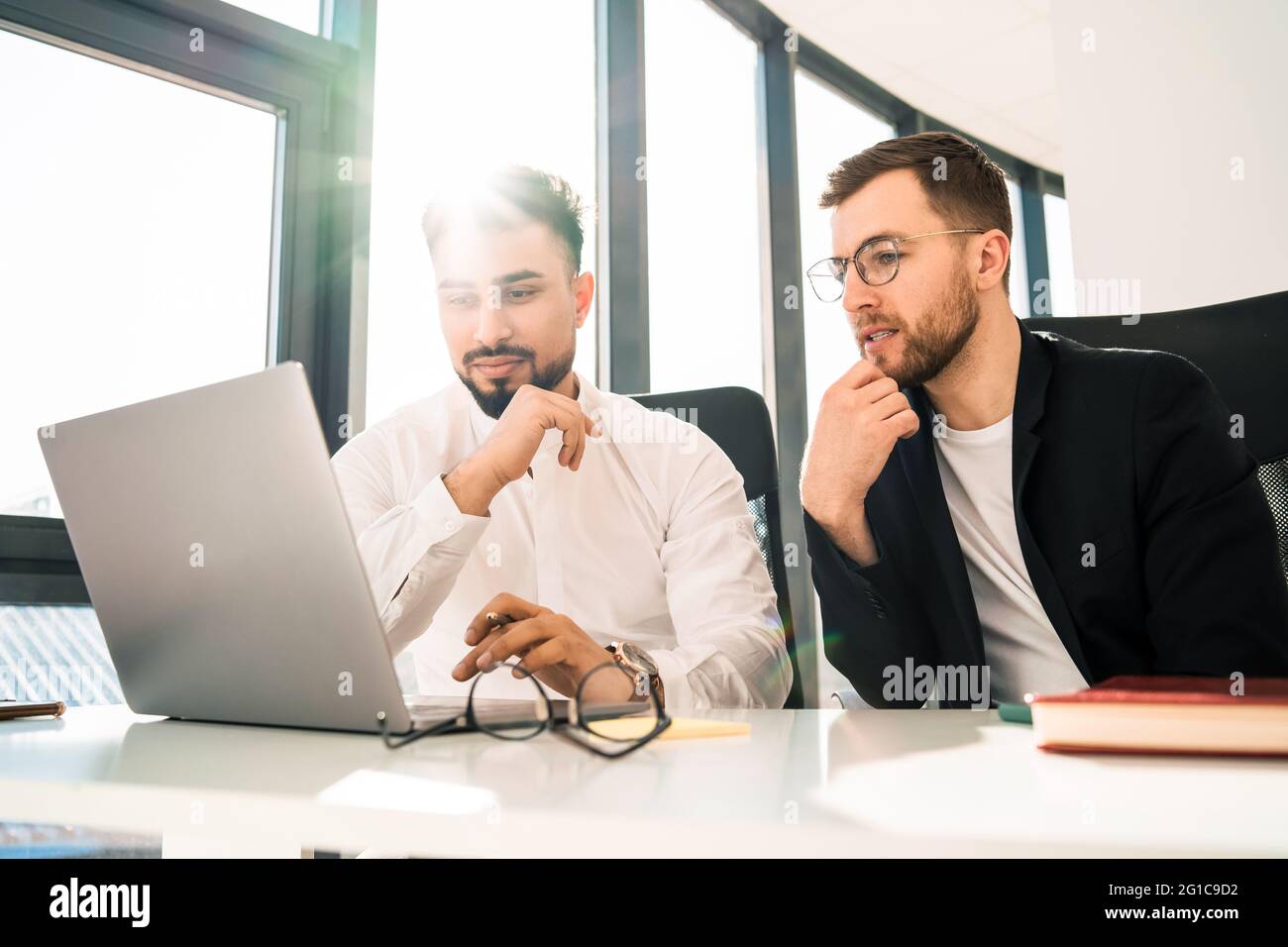 Two handsome businessmen work together on laptop Stock Photo - Alamy