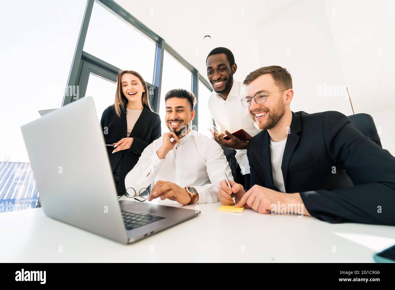 Group of multiracial IT professionals are working gathered behind a ...