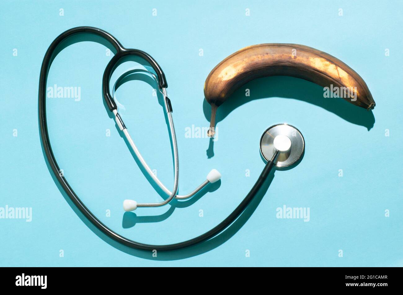 Minimal layout with a rotten banana and a traditional stethoscope with ...