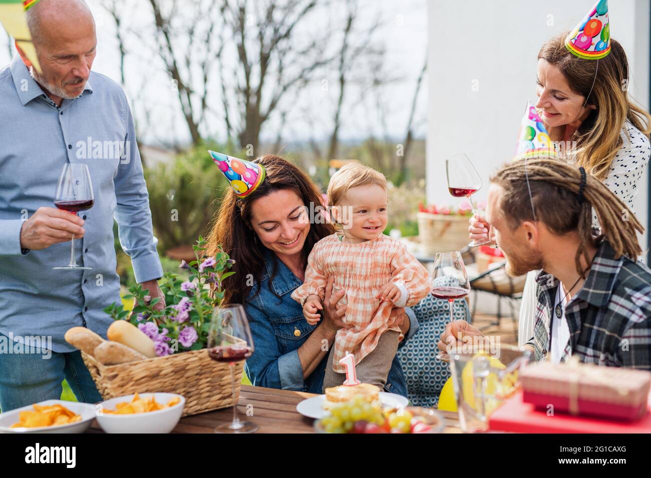 Happy multigeneration family outdoors in garden at home, birthday ...