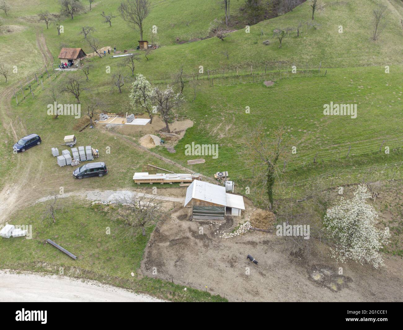 Aerial shot of a rural environment with cars and farm buildings in the ...